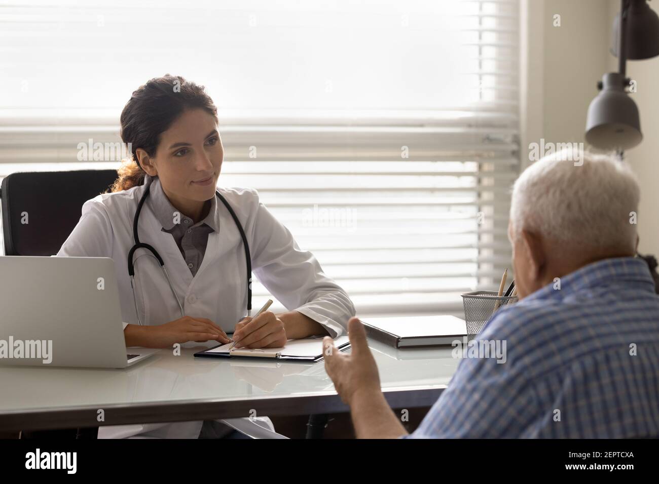 Female doctor therapist listening to patient complaints, filling form ...
