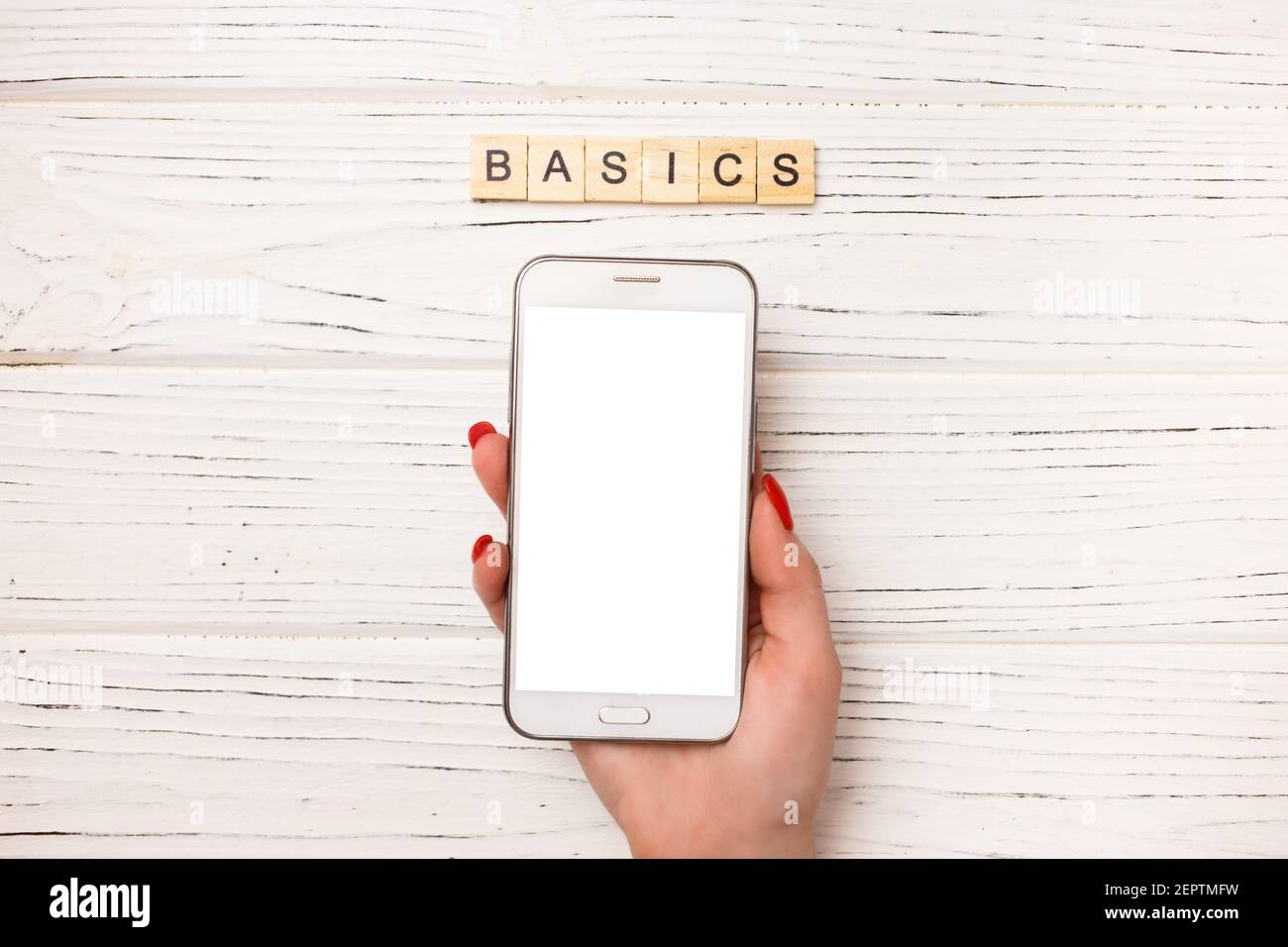 Basic income written on wood blocks with woman hand and smartphone on ... Basic income written on wood blocks with woman hand and smartphone on ...