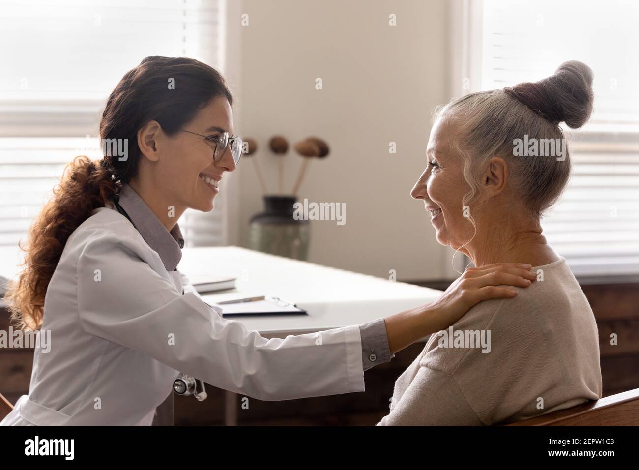 Side view happy doctor touching mature patient woman shoulder Stock ...