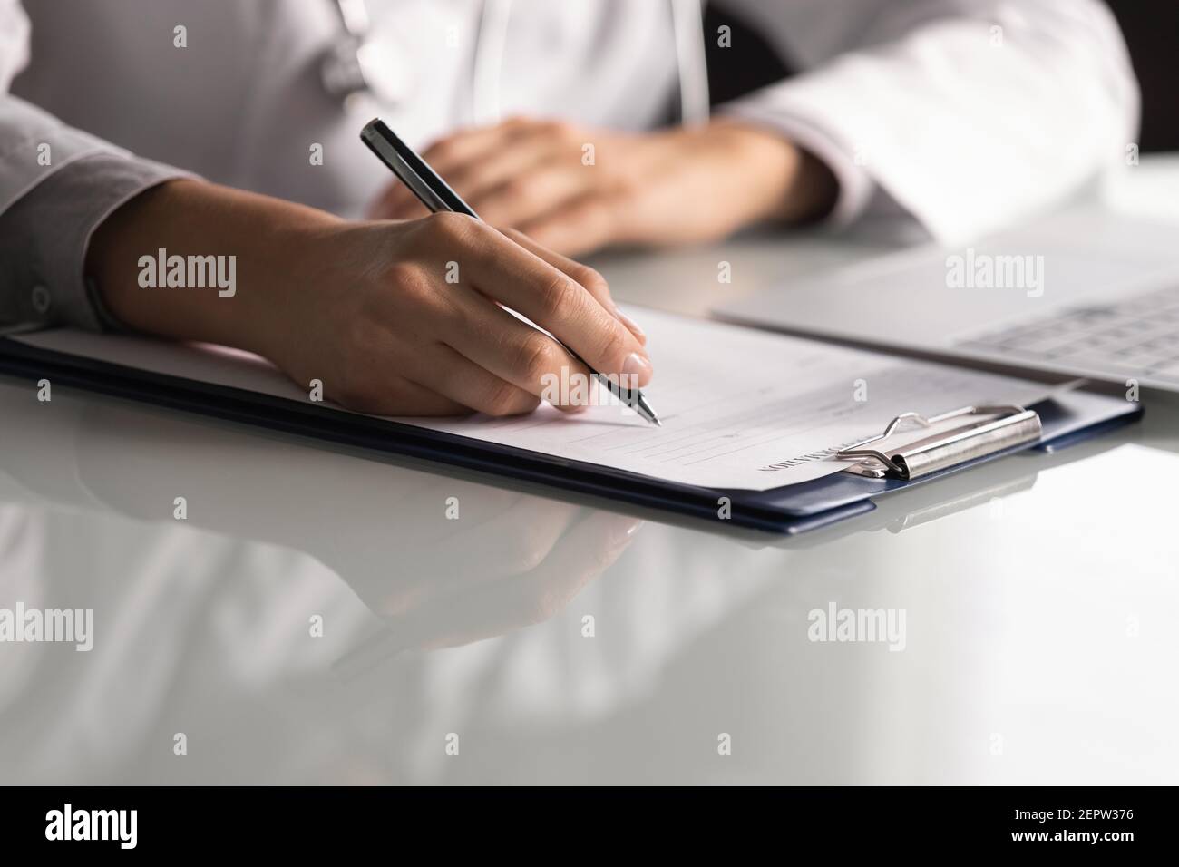 Close up professional female doctor taking notes, filling medical ...