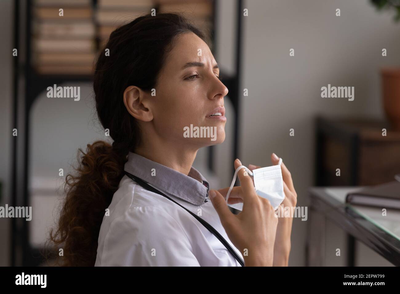 Head shot tired woman doctor taking off face mask Stock Photo - Alamy