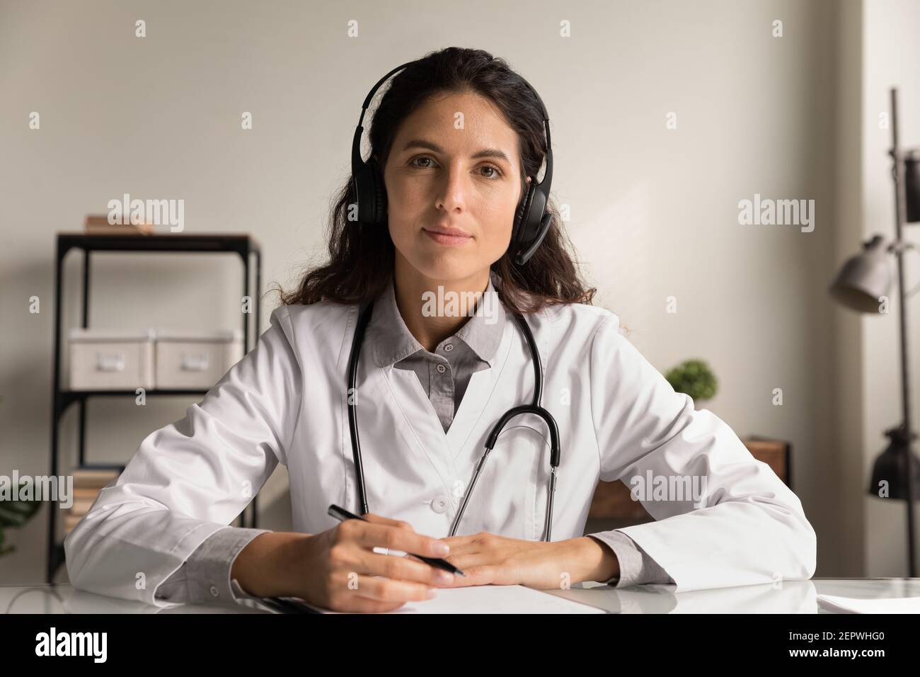 Head shot portrait confident female doctor wearing headphones taking ...