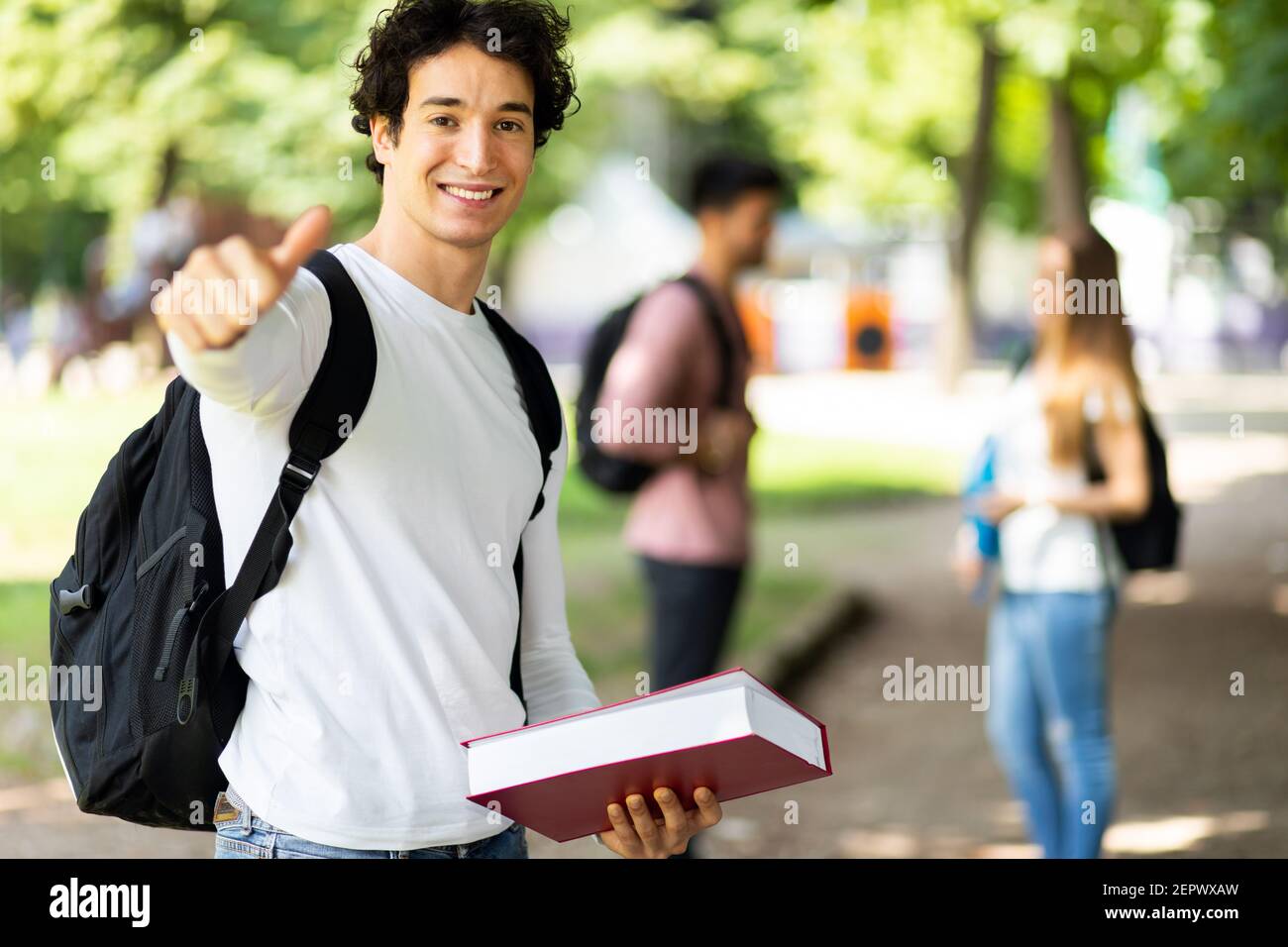 Happy student outdoor smiling confidently and giving thumbs up Stock ...