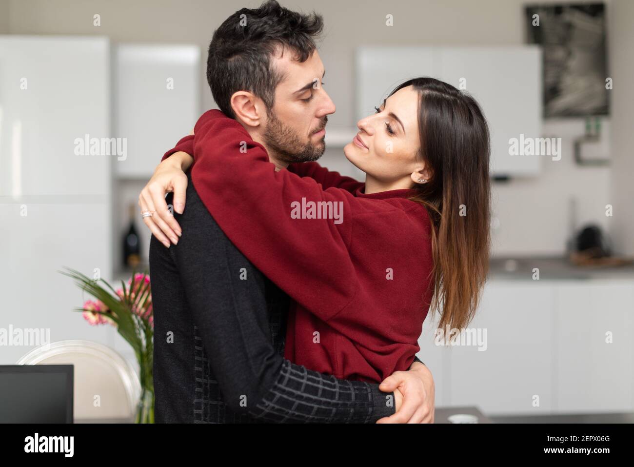 Happy couple hugging in their home Stock Photo - Alamy