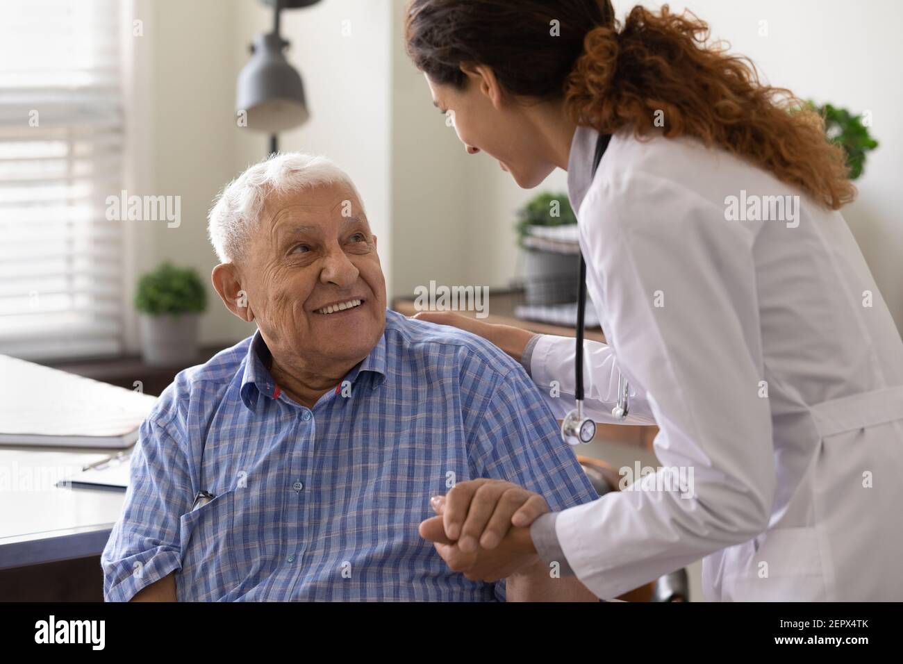 Close up caring nurse holding smiling mature patient hand Stock Photo ...