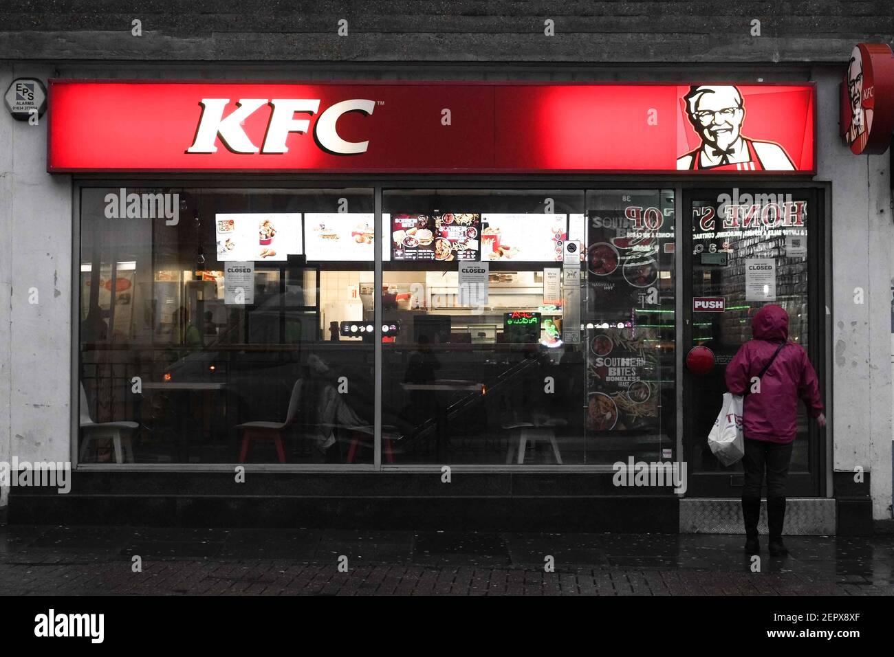 A women reads a closed sign in a KFC restuarant window in Woolwich ...