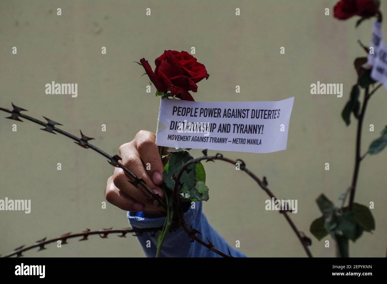 An activist hangs a flower and a note against the administration's ...