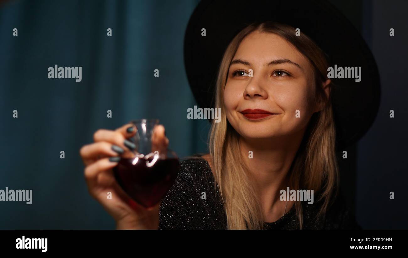 Cropped image of woman holding heart shaped glass jar of love potion ...