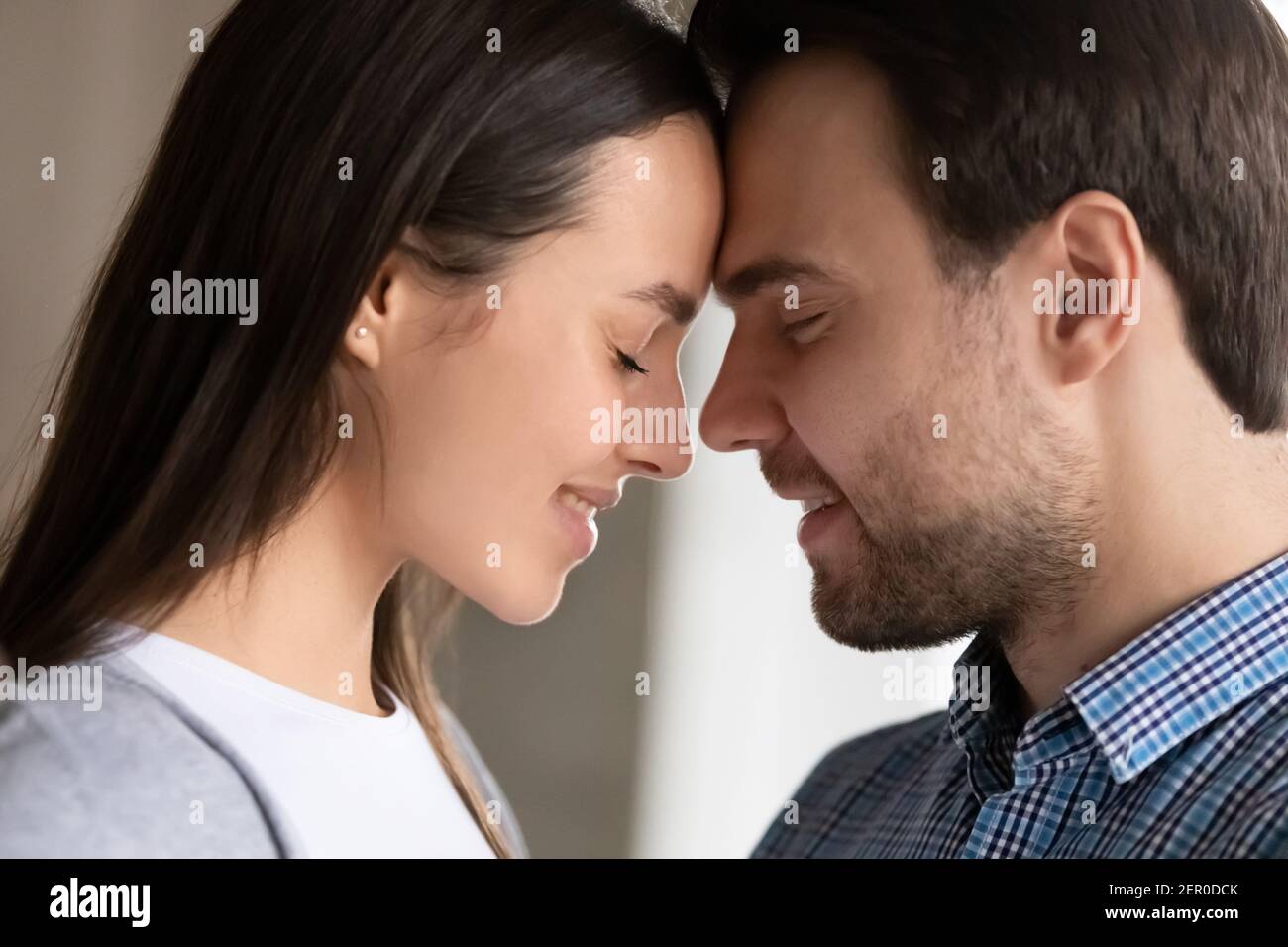 Happy millennial couple in love touching with foreheads Stock Photo - Alamy