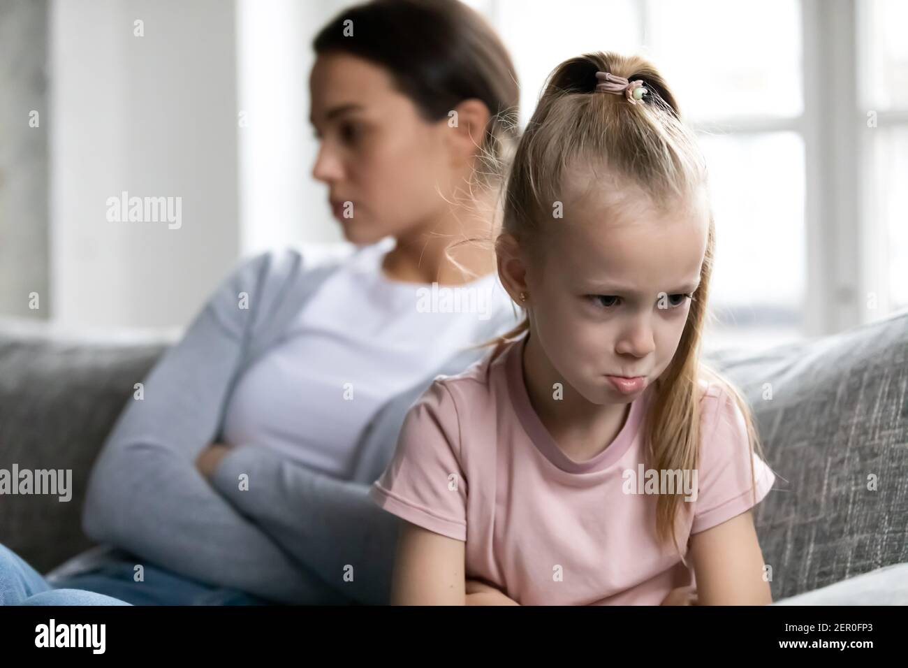 Annoyed upset quiet mother and kid sitting on couch separately Stock ...