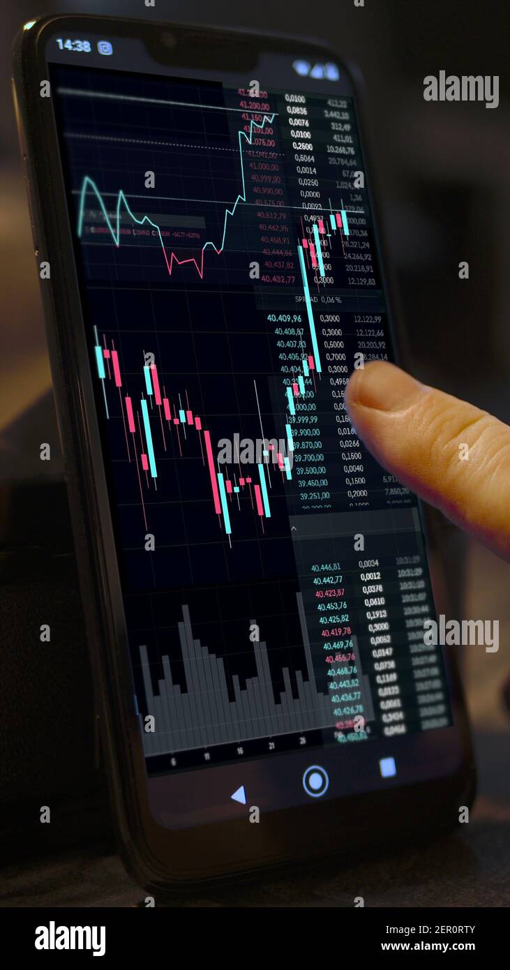 Stock price graphs on a smart phone with a finger touching the display ...