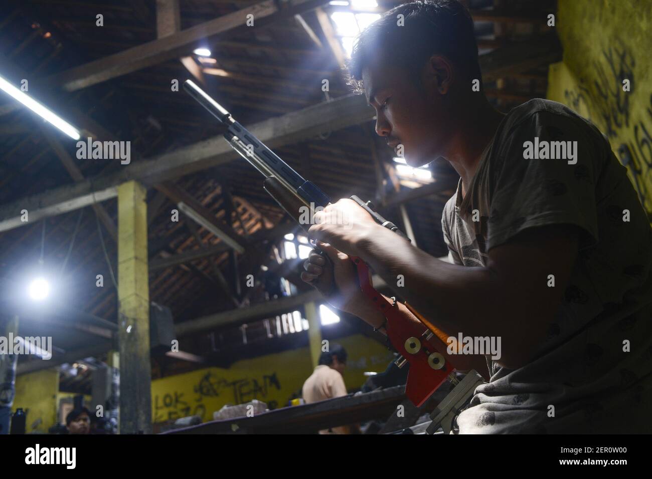 Indonesian gunsmiths checks the rifle in a small air rifle factory in ...
