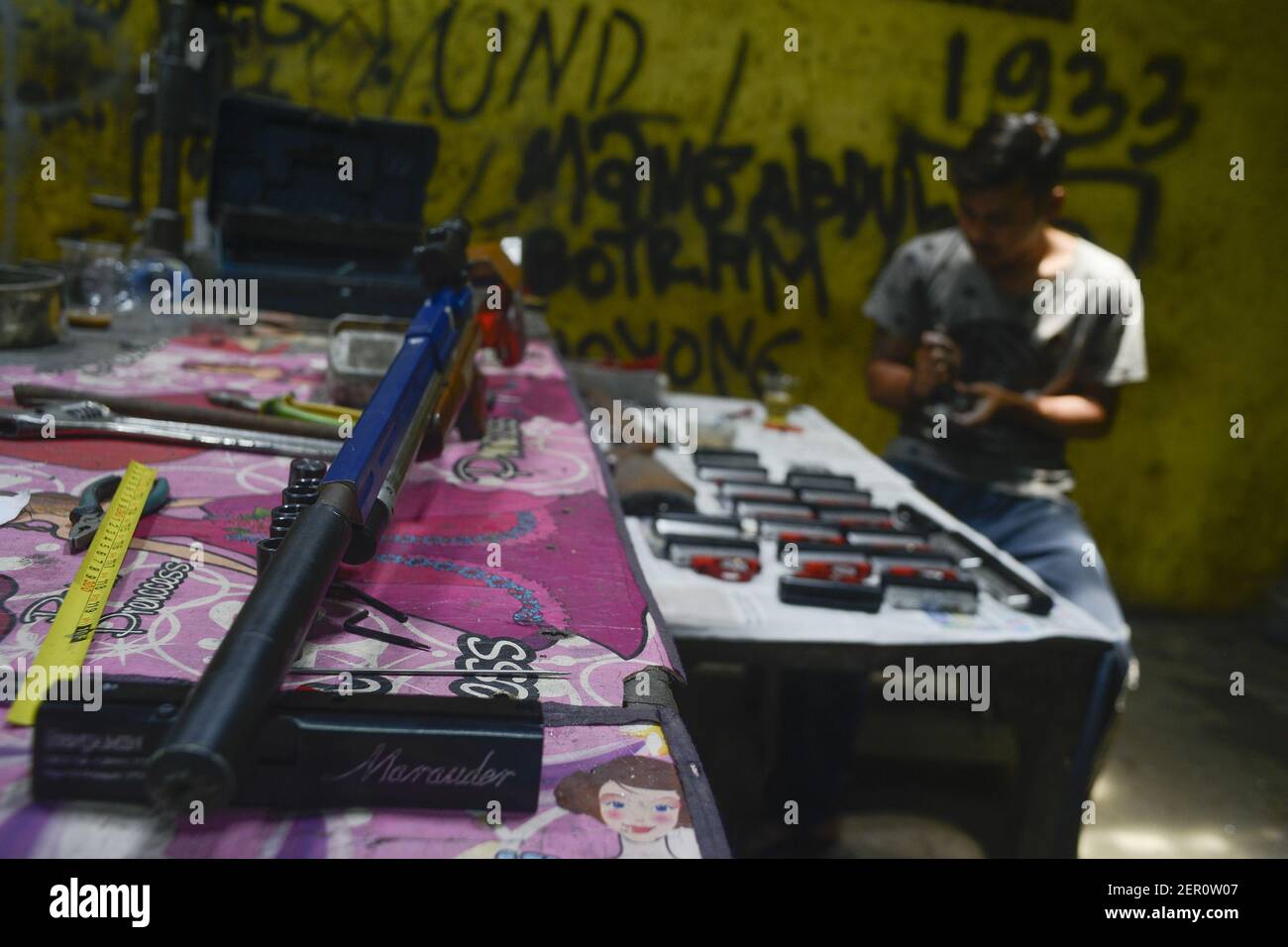 Indonesian gunsmiths checks the rifle in a small air rifle factory in ...