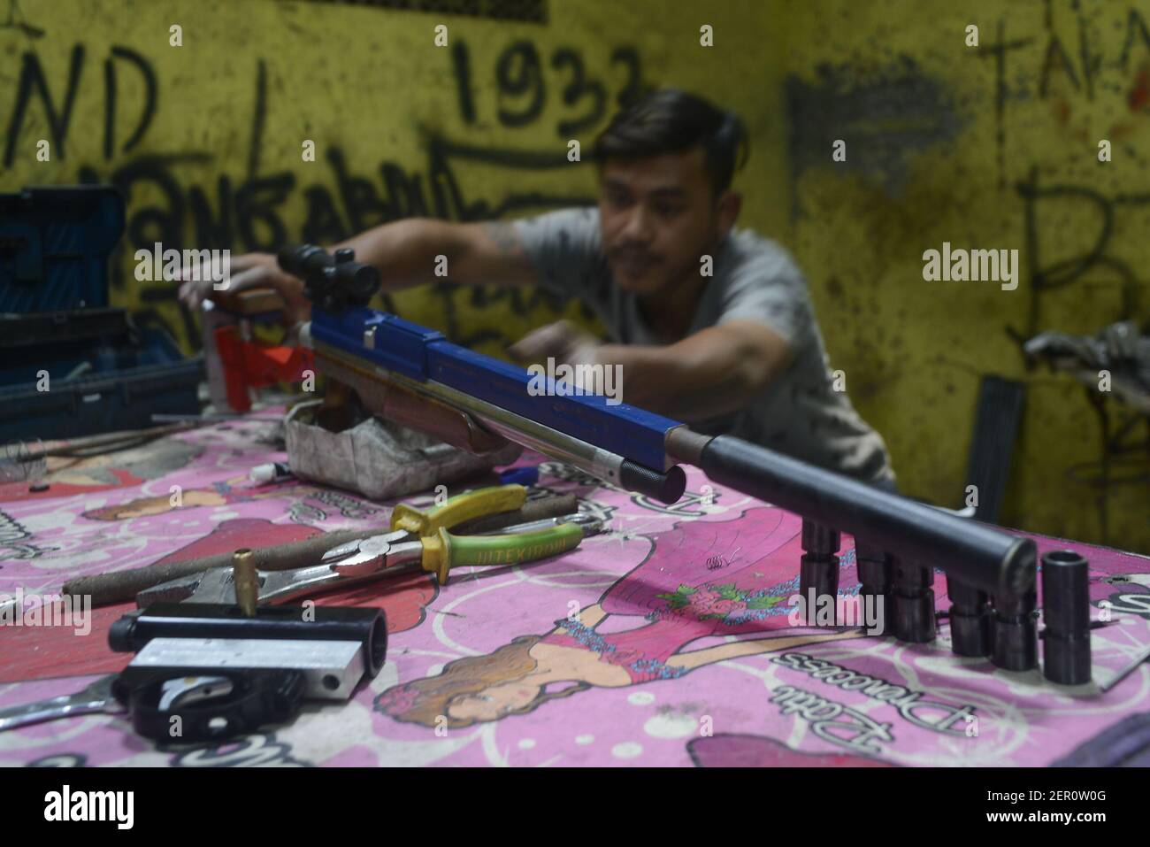 Indonesian gunsmiths checks the rifle in a small air rifle factory in ...