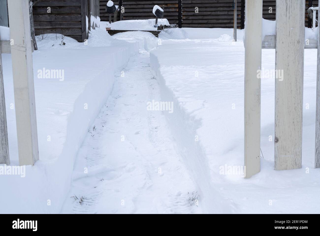 Snow plow track in high snow levels in winter Stock Photo - Alamy