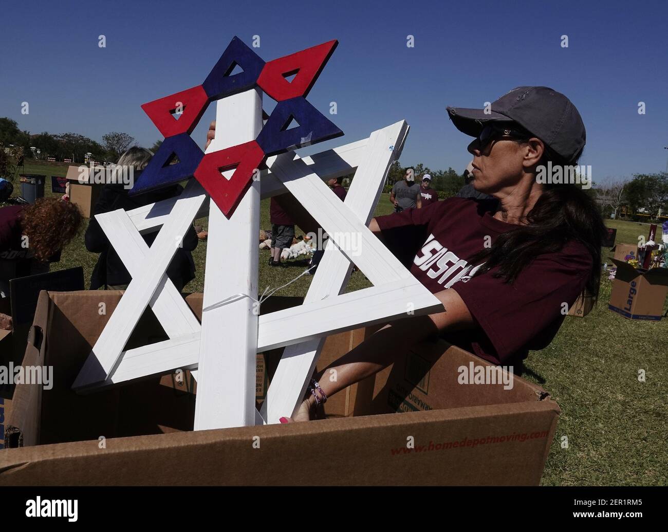 Volunteer Stacey Udine removes items left at the memorials for the ...