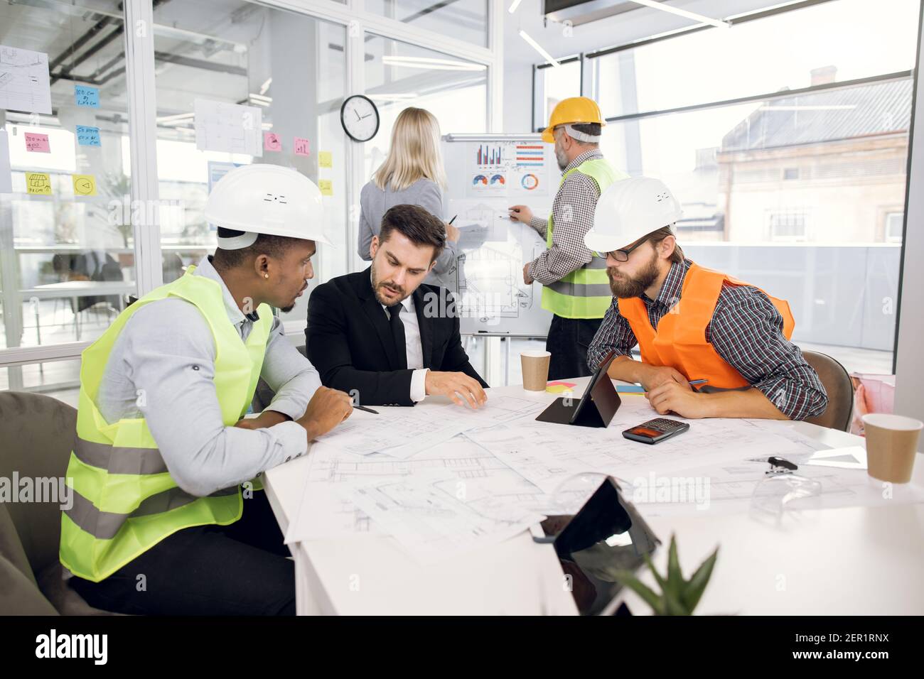 Multiethnic group of engineers and builders, working together over ...