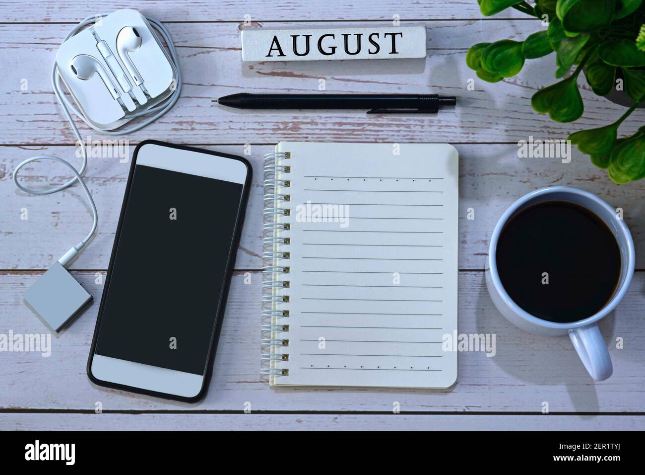 Directly above view of wooden desk with August text on white wood block ...