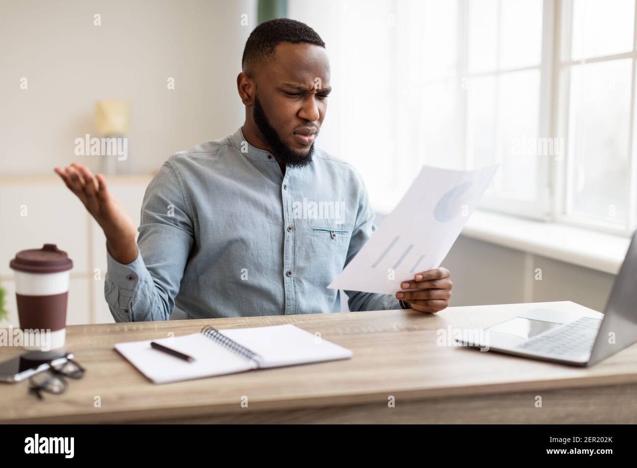 Shocked African Businessman Looking Through Negative Financial Report ...