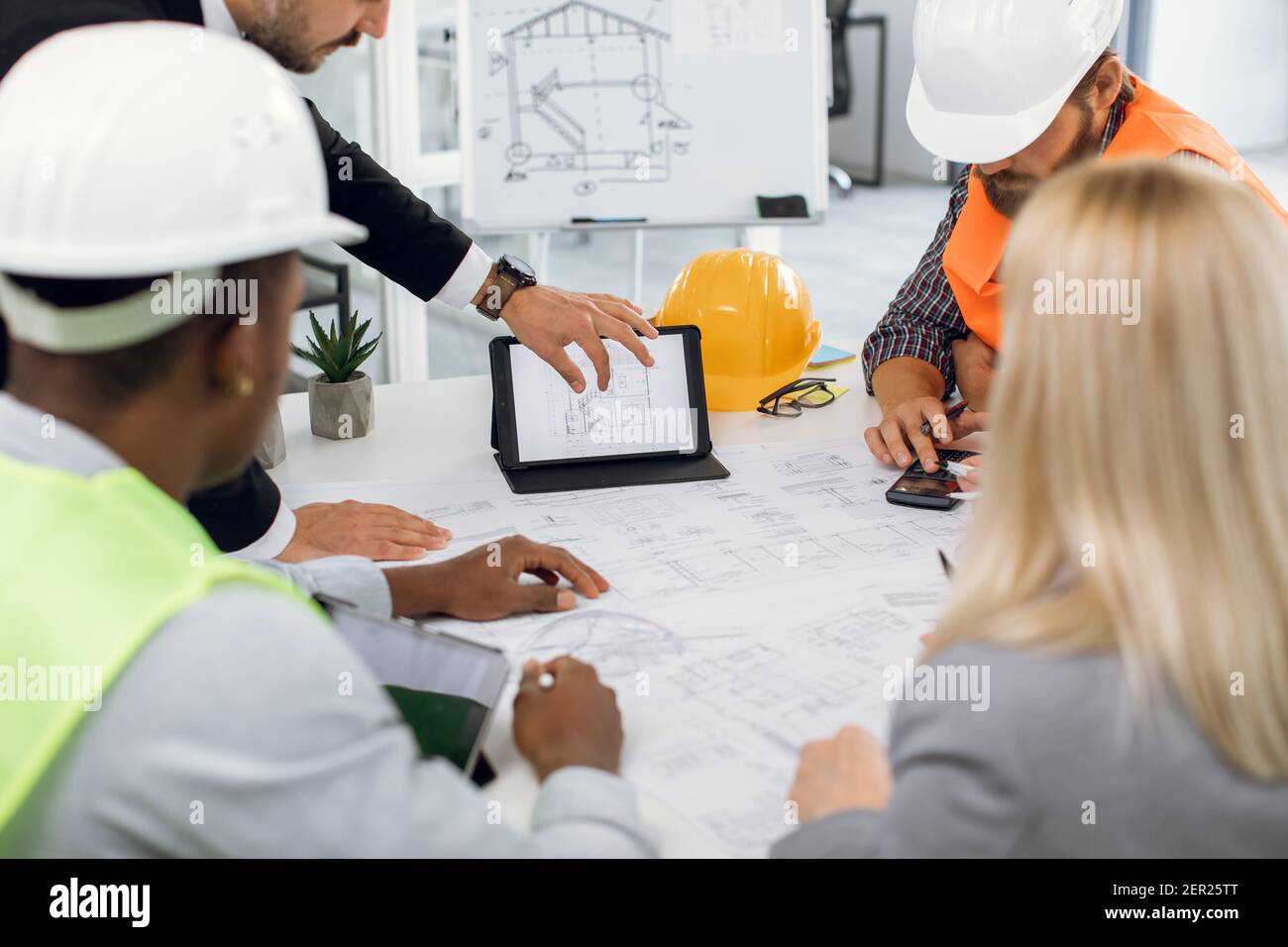 Workers using gadgets for creating plan of construction Stock Photo - Alamy
