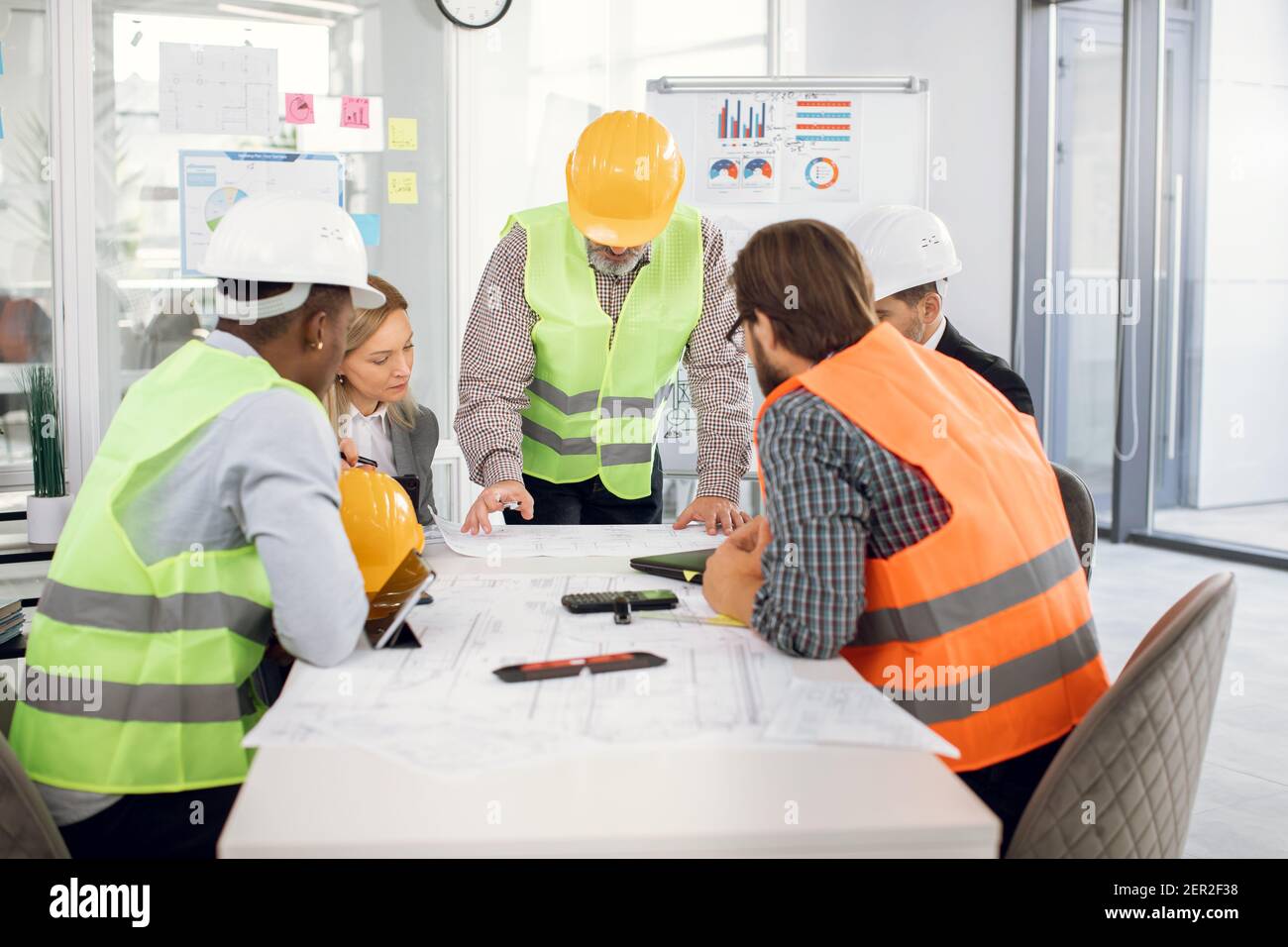 Diverse architect people sitting at office with blueprints Stock Photo ...