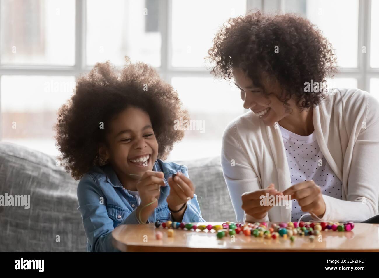 Happy excited Black mother and daughter kids sharing craft hobby Stock ...