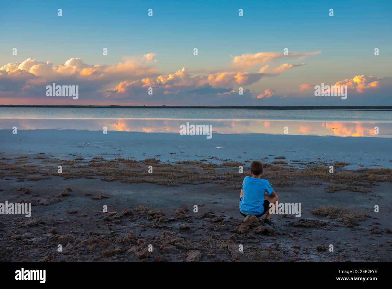Boy looking at the horizon at sunset Stock Photo - Alamy