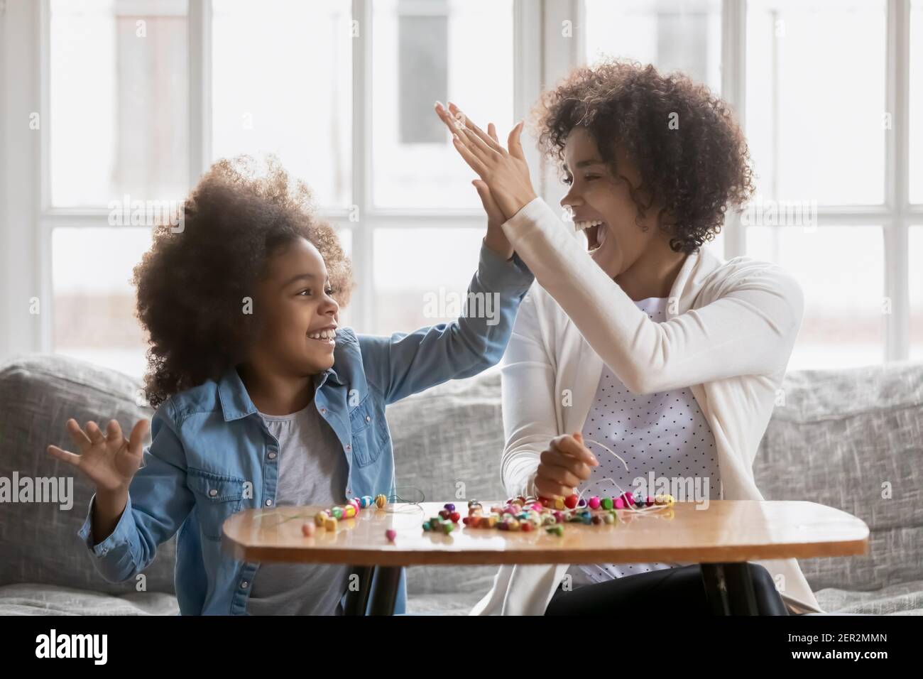 Proud mom giving high five to daughter Stock Photo - Alamy