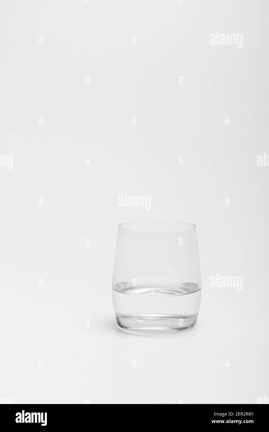 The half full glass of pure water isolated on a white background. A ...