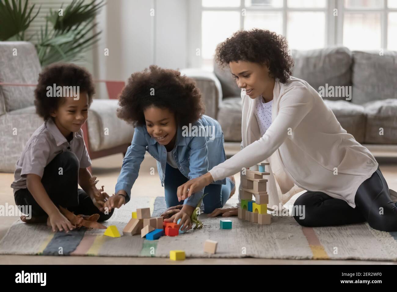 Happy black kids and mom playing with wooden construction blocks Stock ...