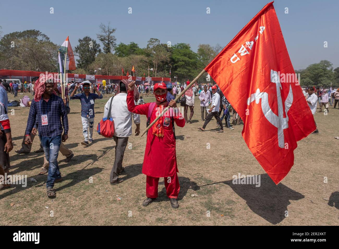 A supporter dressed in party colours is seen holding a party flag ...
