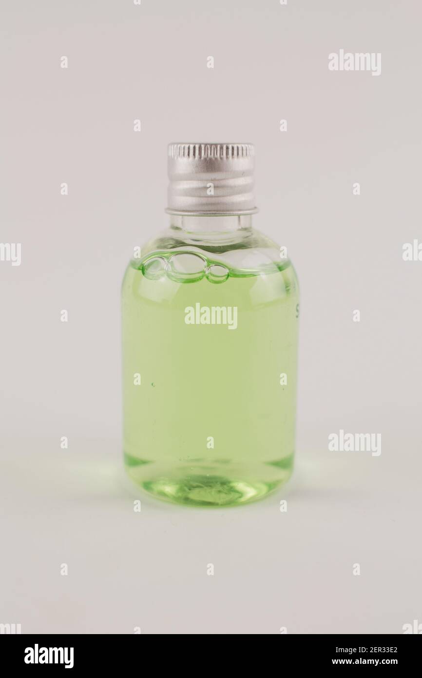 a light green shampoo in a transparent bottle on a white background ...