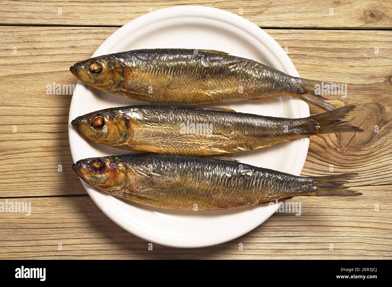 Smoked herring in white plate on old wooden table, top view Stock Photo ...