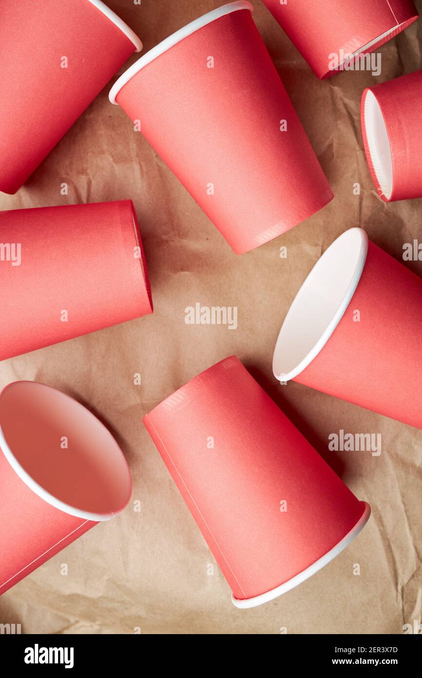 pile of disposable red paper cups on paper background. eco friendly ...