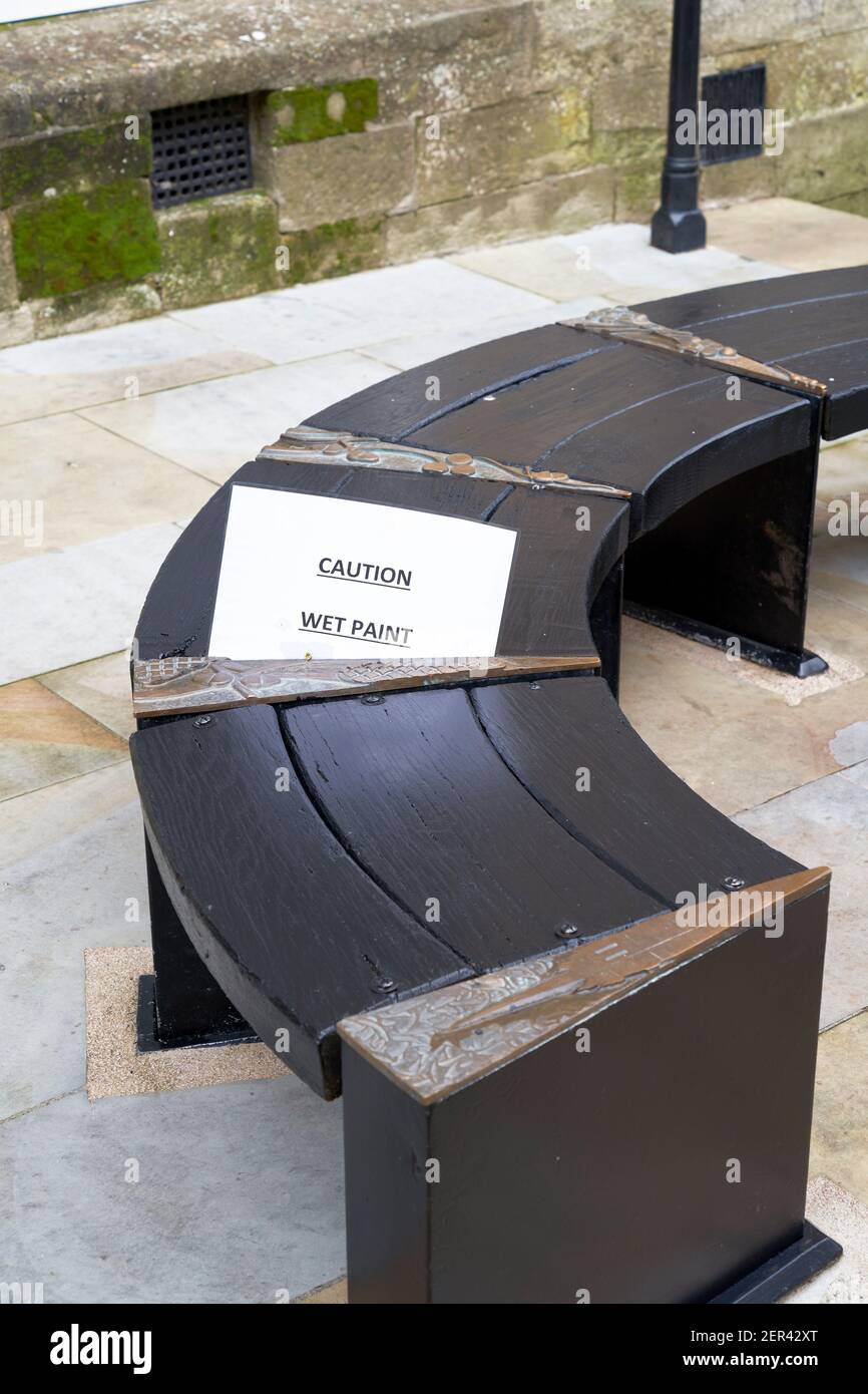 Caution wet paint notice on public bench seat Stock Photo - Alamy