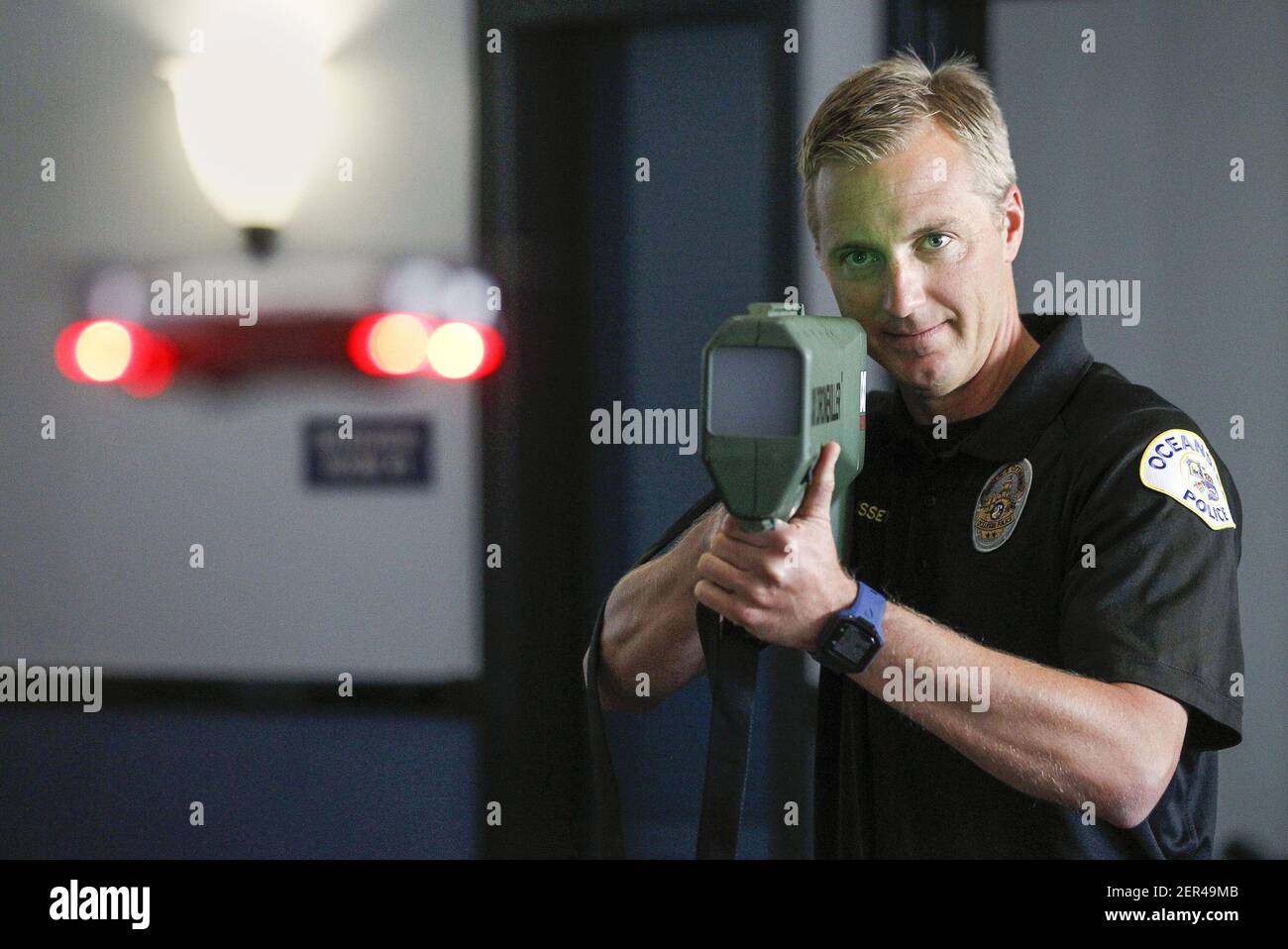 Oceanside police officer Mark Bussey, who is with the Harbor Unit, aims ...
