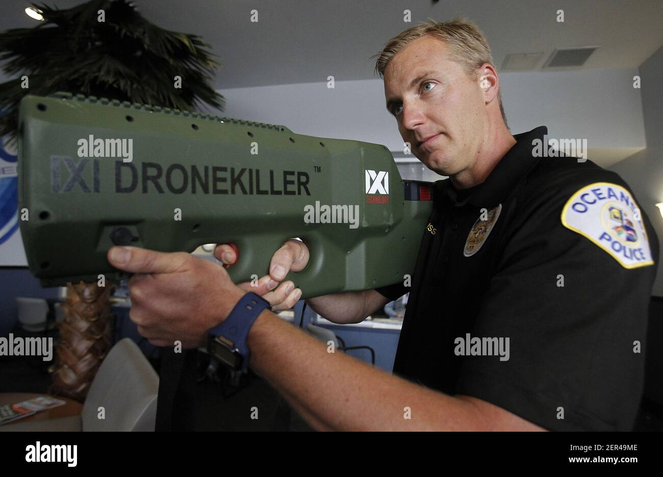 Oceanside police officer Mark Bussey, who is with the Harbor Unit, aims ...