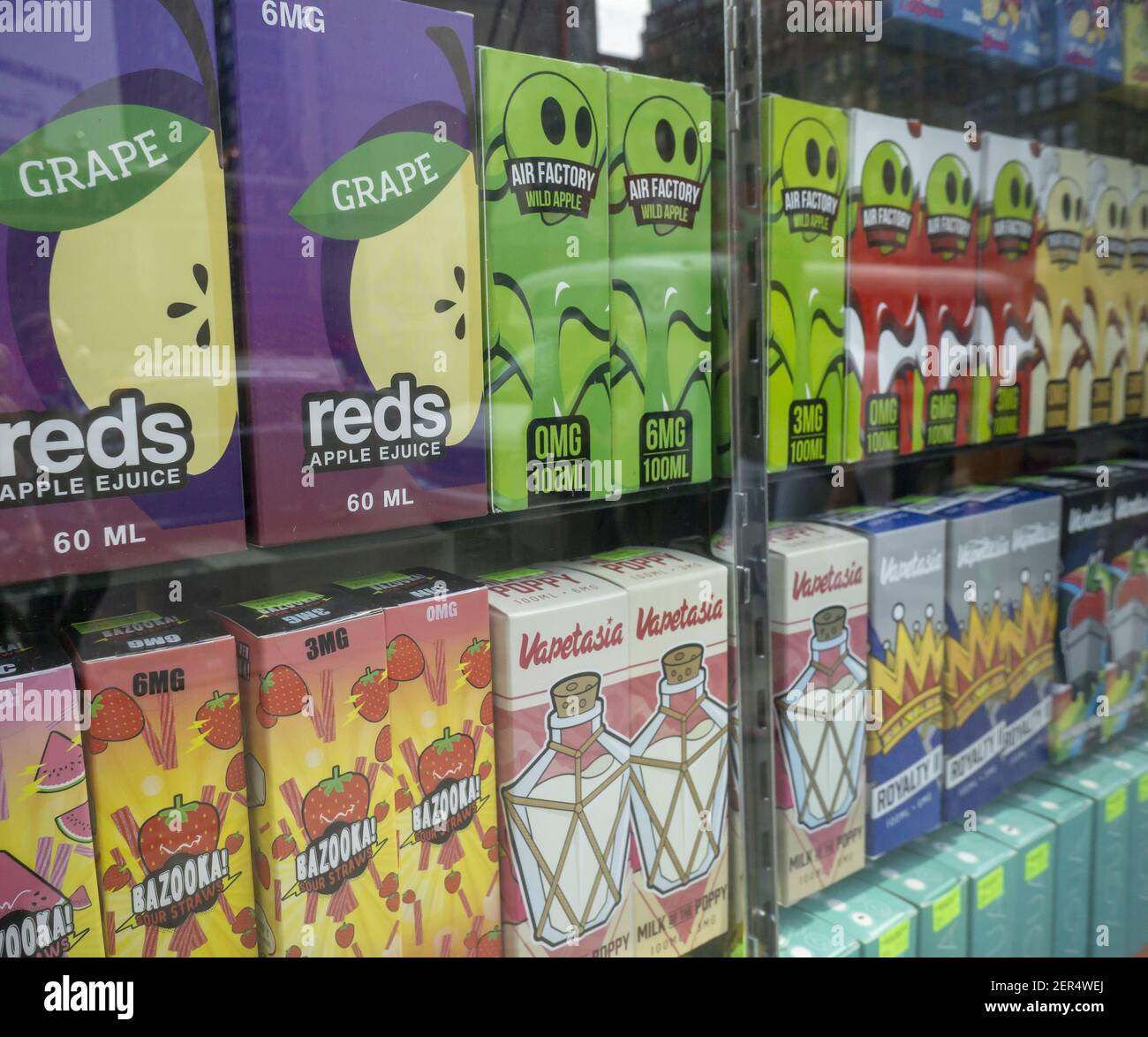 A selection of flavored vaping supplies on display in the window of a ...