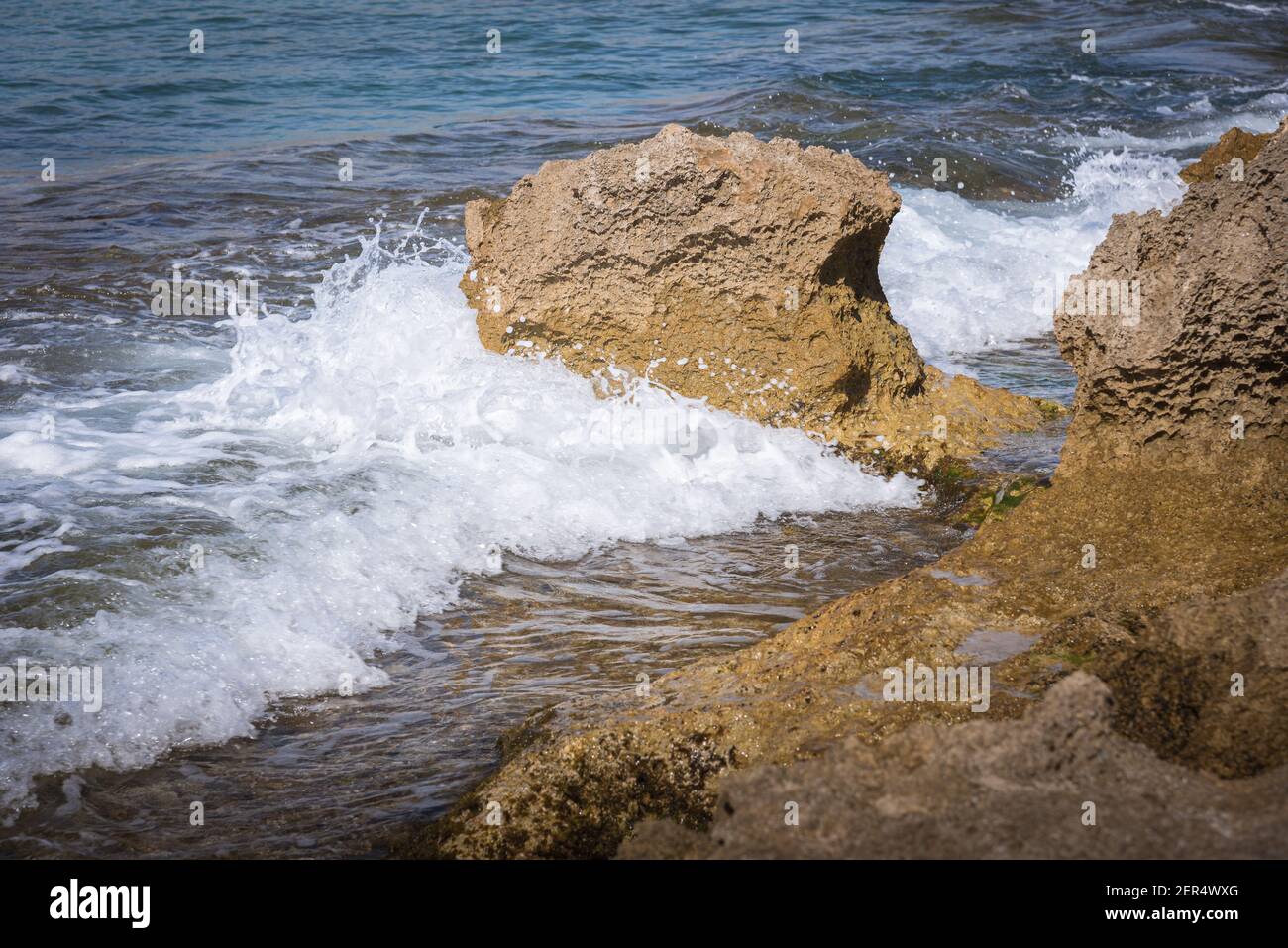 Sea foam from waves breaking against the rocks Stock Photo - Alamy