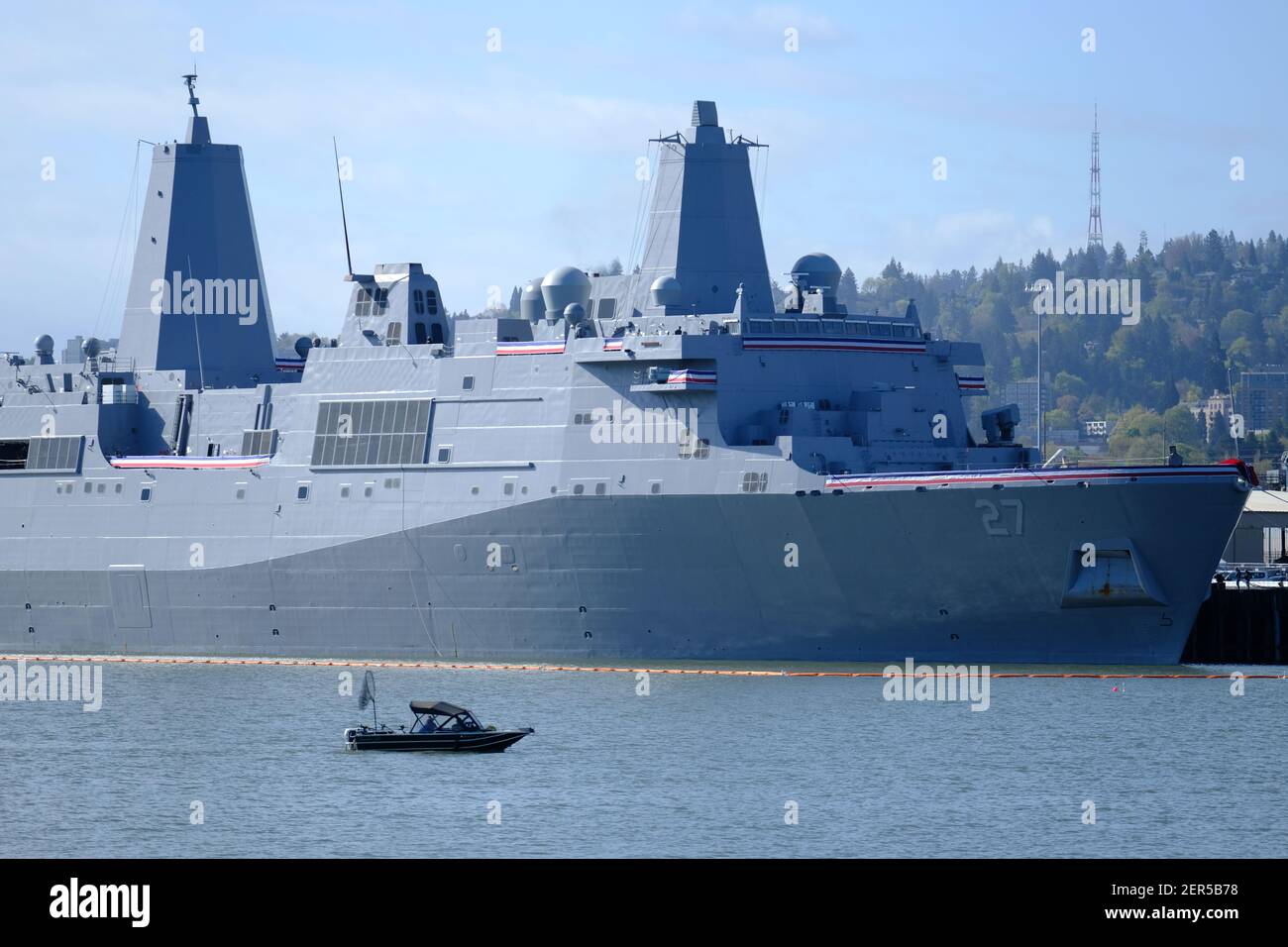 A fisherman drifts past the USS Portland (LPD-27) in Portland, Ore ...