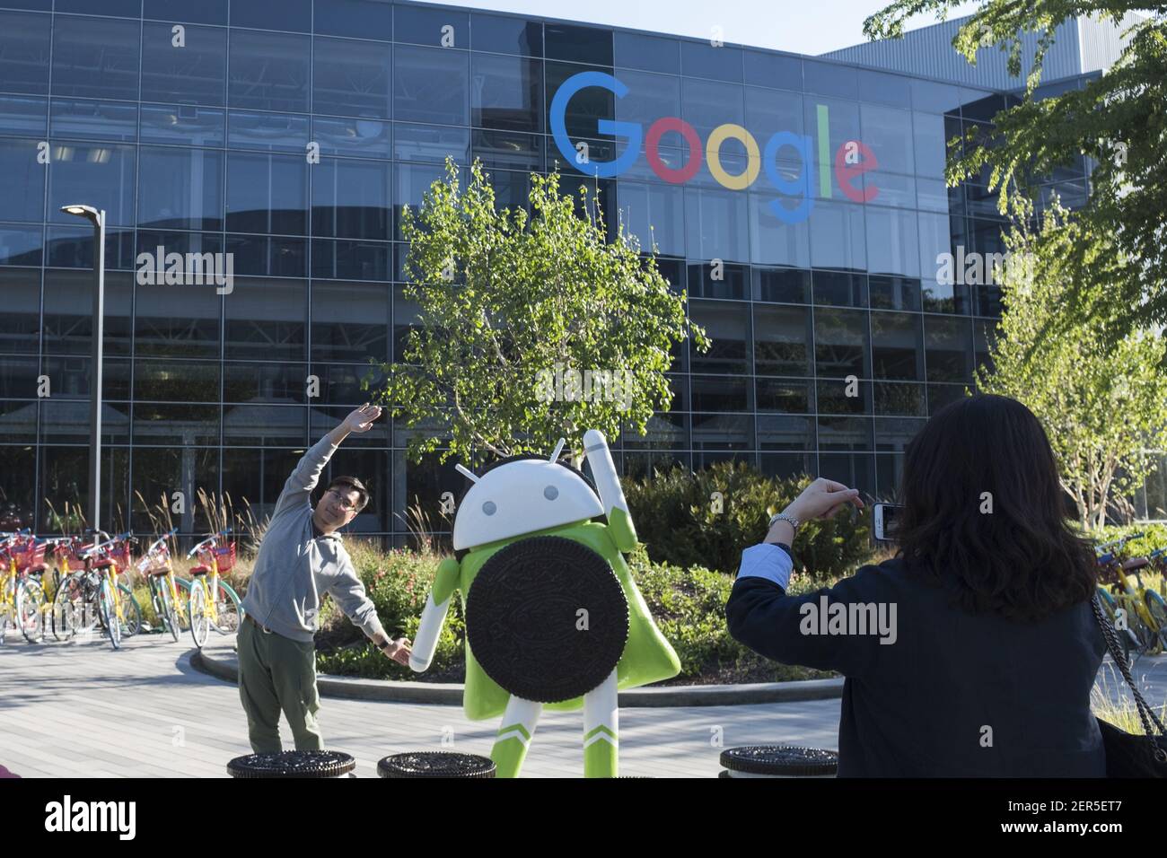 Tourists are seen taking pictures in front of a sign of Google at its ...