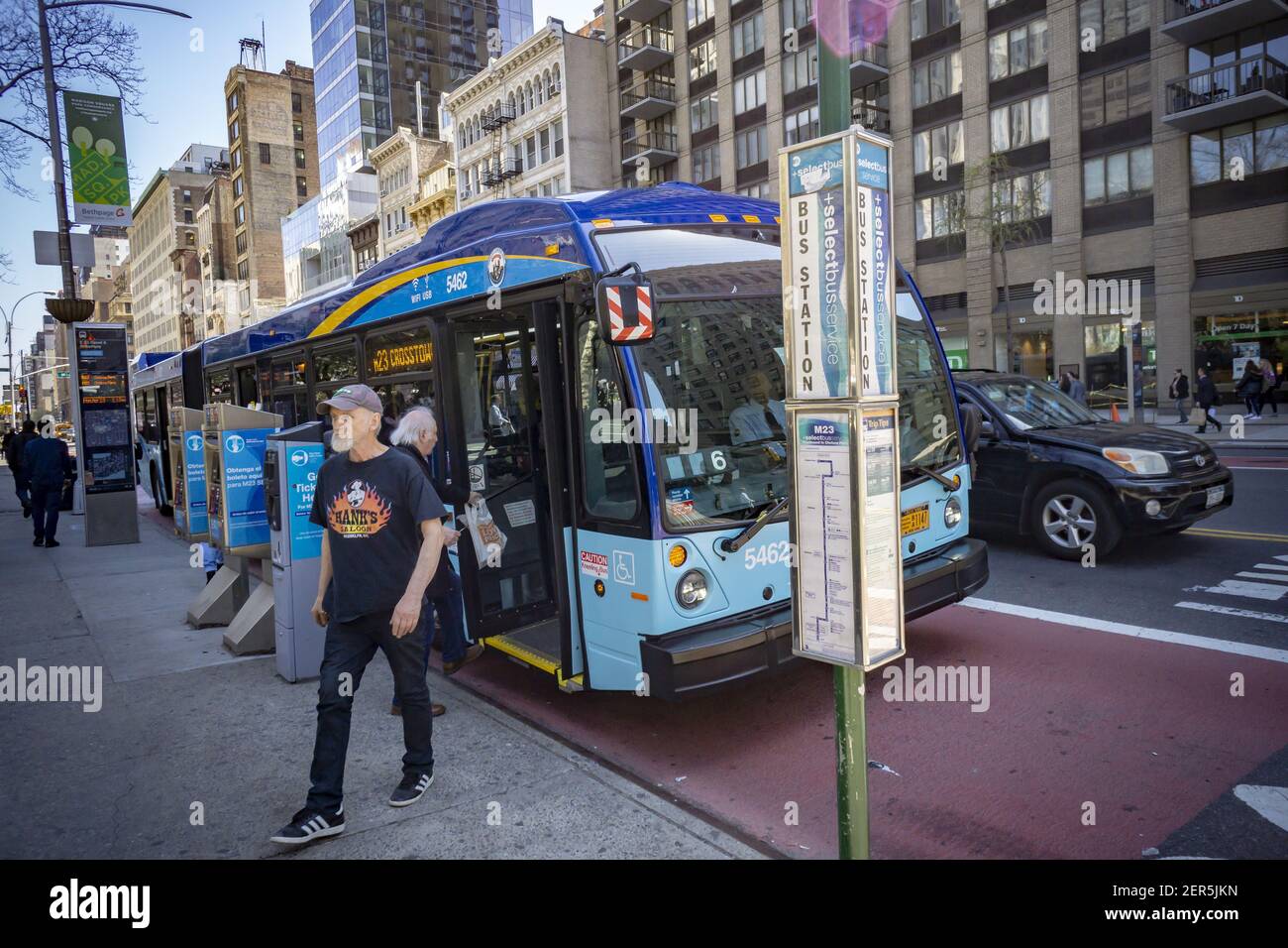 Passengers board and depart a Select Bus Service bus on the M23 route ...