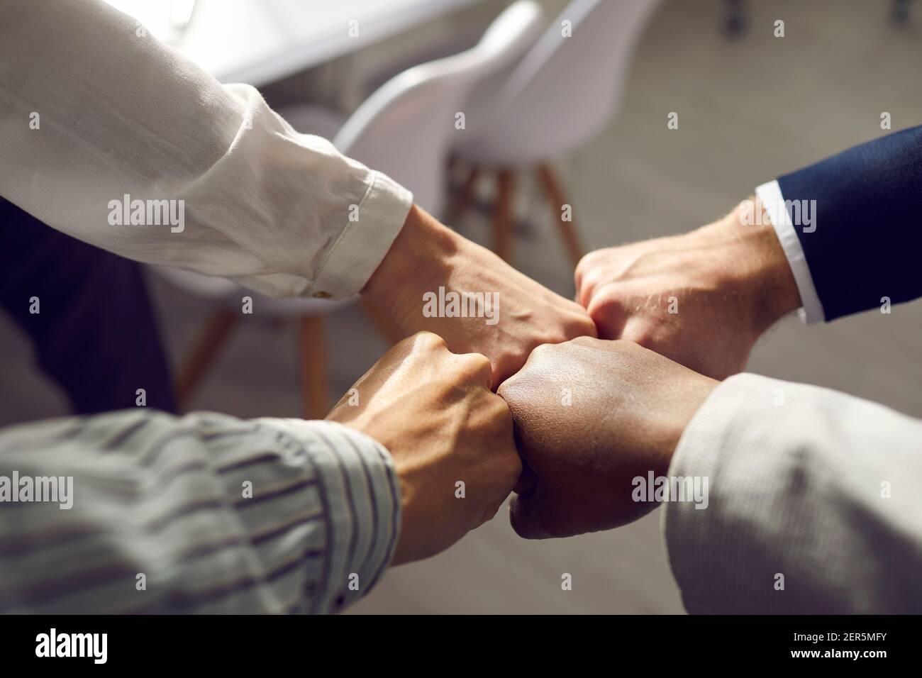 Close up of hands of business partners folding fists together as a ...