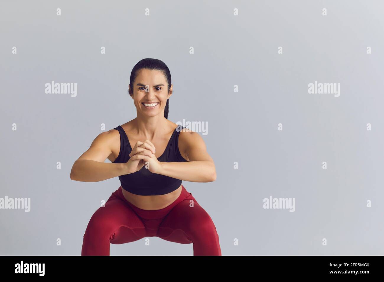 Woman looking camera doing squats hi-res stock photography and images ...