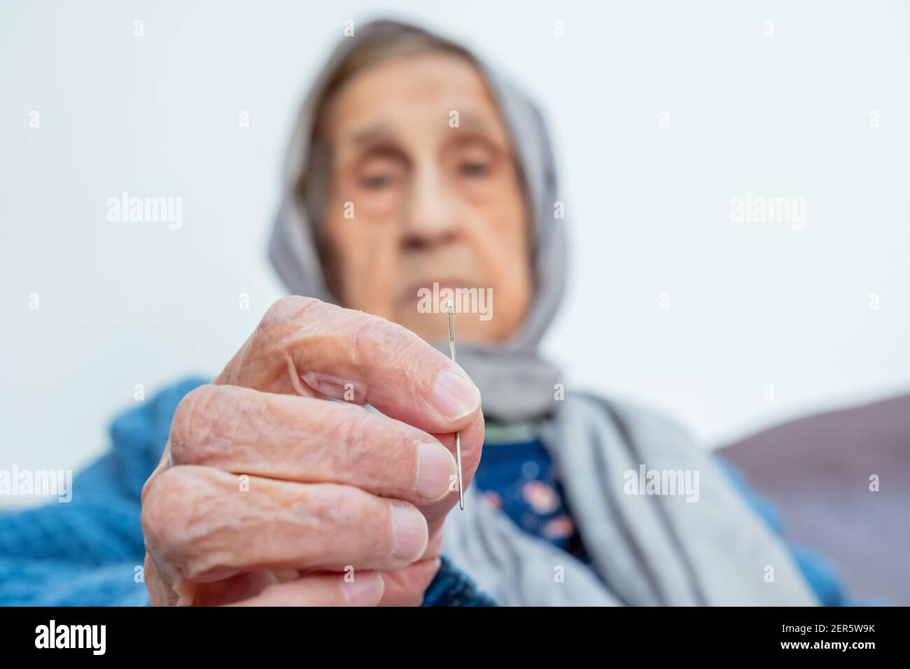 Arabic muslim old woman inserting thread in needle Stock Photo - Alamy