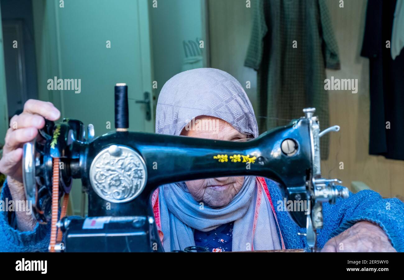 Arabic muslim old woman using old sewing machine Stock Photo - Alamy
