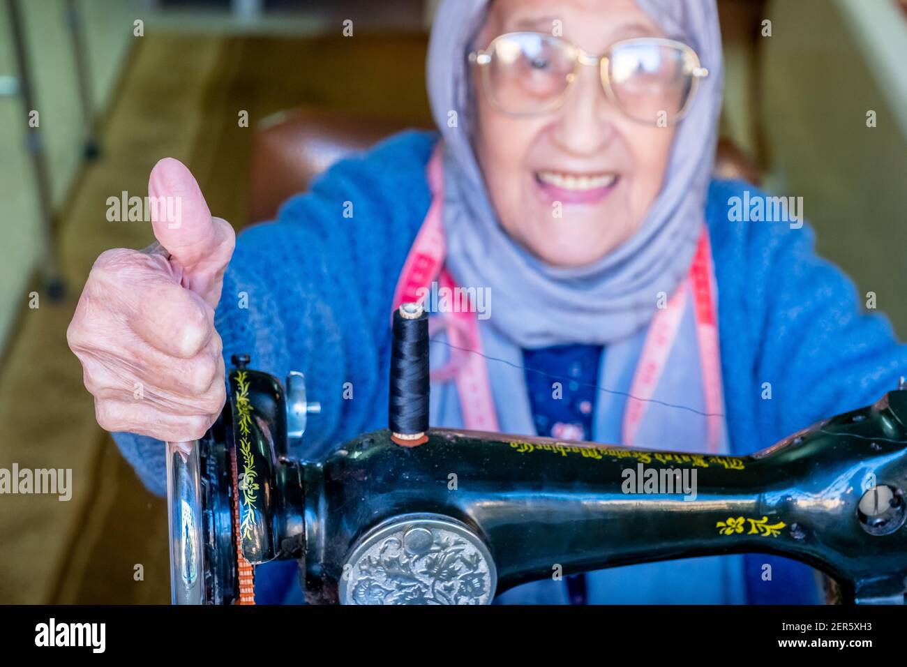 Arabic muslim old woman happy while using sewing machine Stock Photo ...
