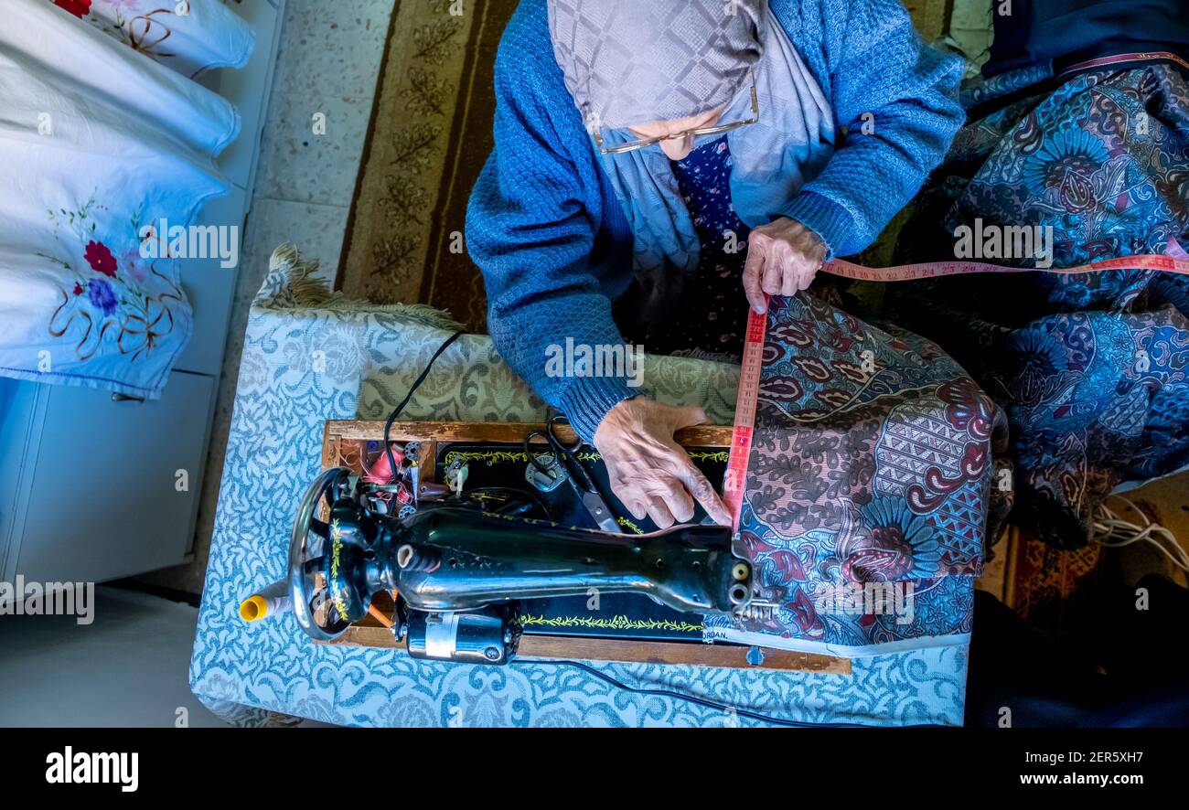 Arabic muslim woman sewing and measuring lengths with her tape Stock ...