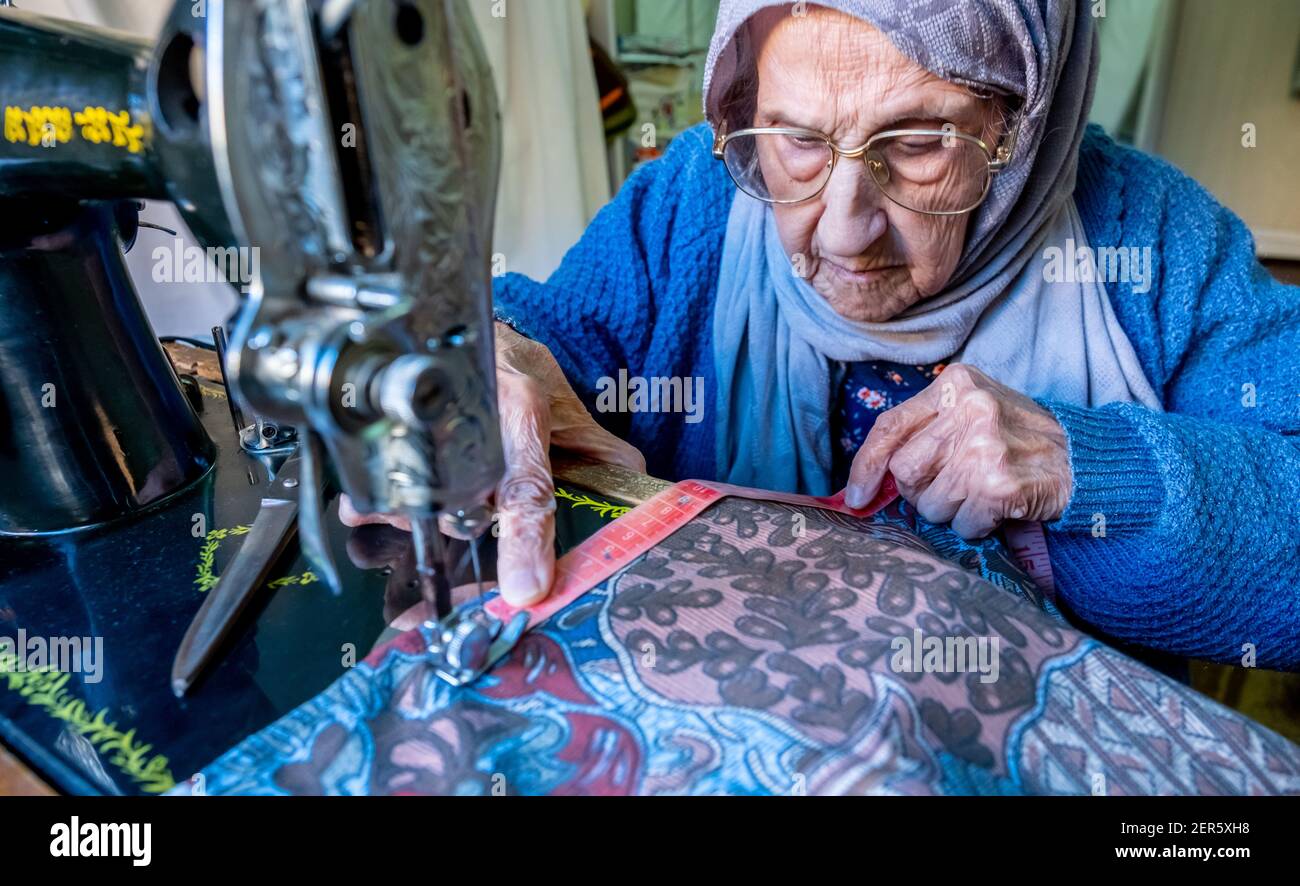 Arabic muslim woman sewing and measuring lengths with her tape Stock ...