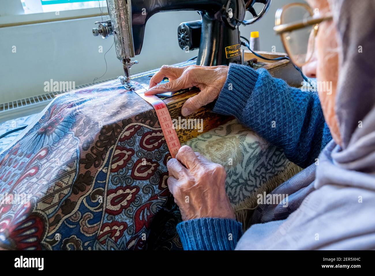 Arabic muslim woman sewing and measuring lengths with her tape Stock ...